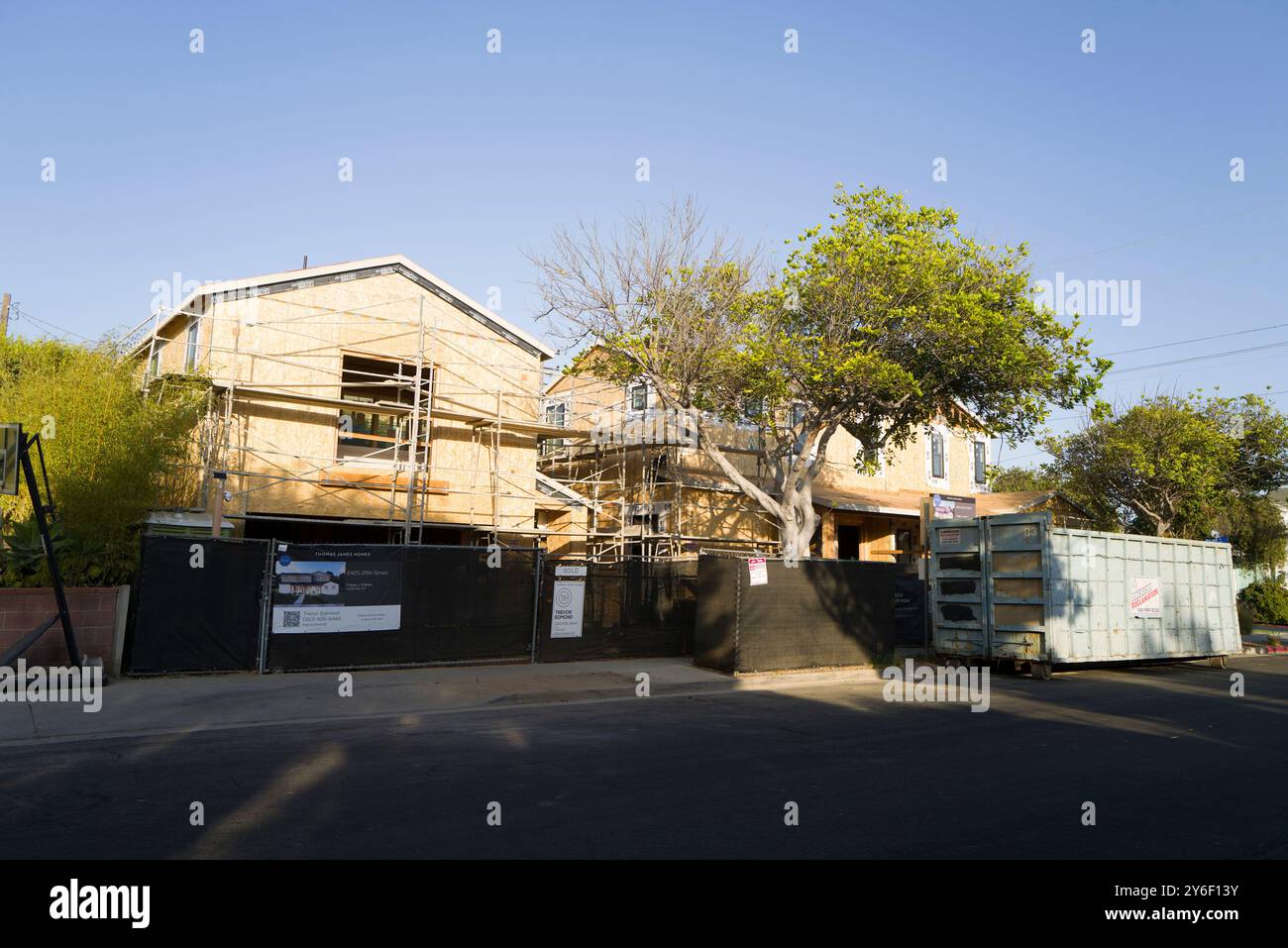 New homes under construction with scaffolding and plywood walls ...