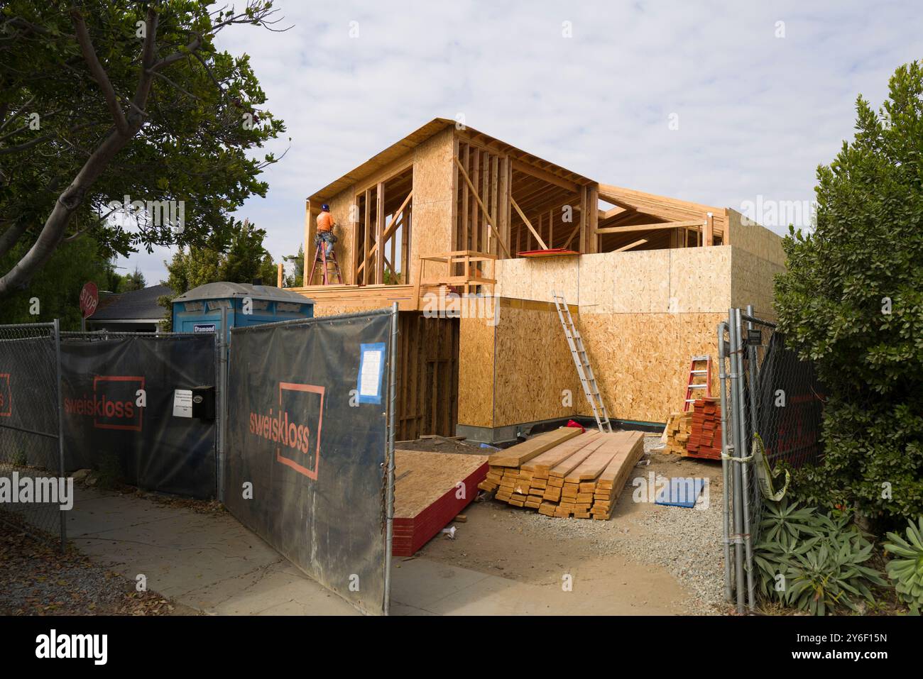 New homes under construction with scaffolding and plywood walls ...