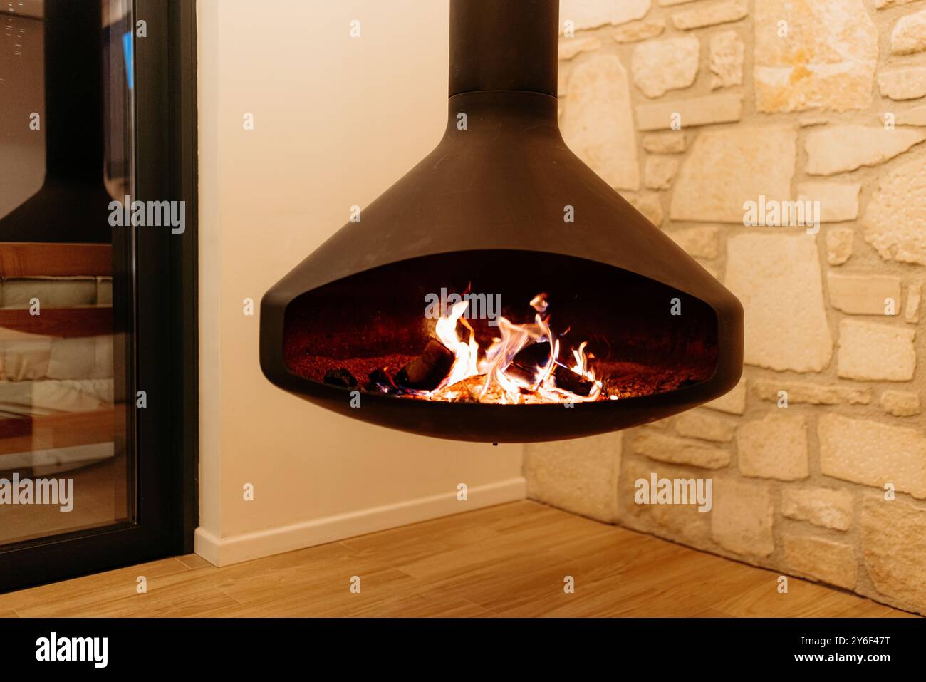 Modern hanging fireplace with a cozy fire in a stylish living room with ...