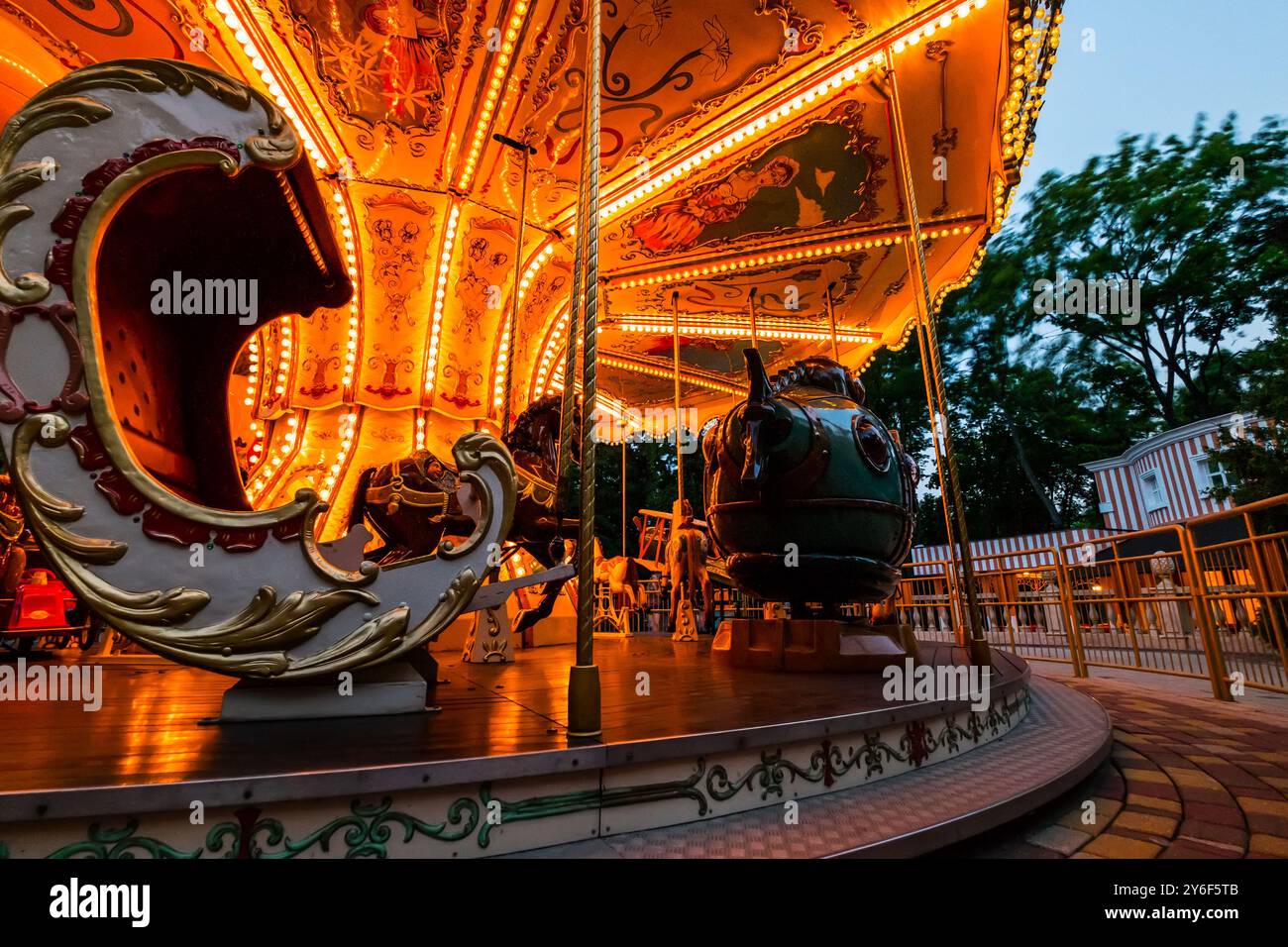 Night view of brightly illuminated merry go round carousel in amusement park, close up Stock ...