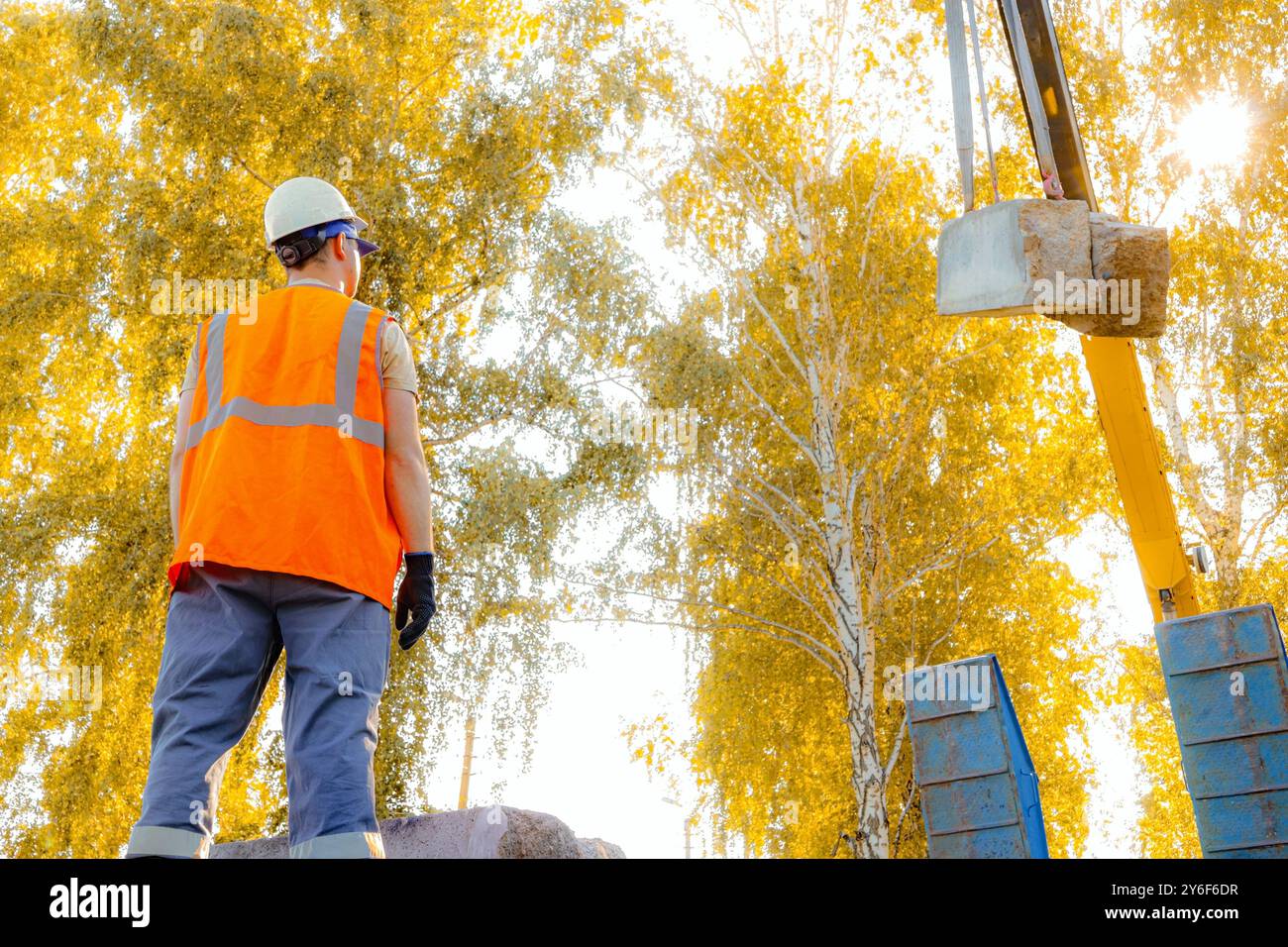 Construction worker in safety gear, including hard hat and orange vest ...