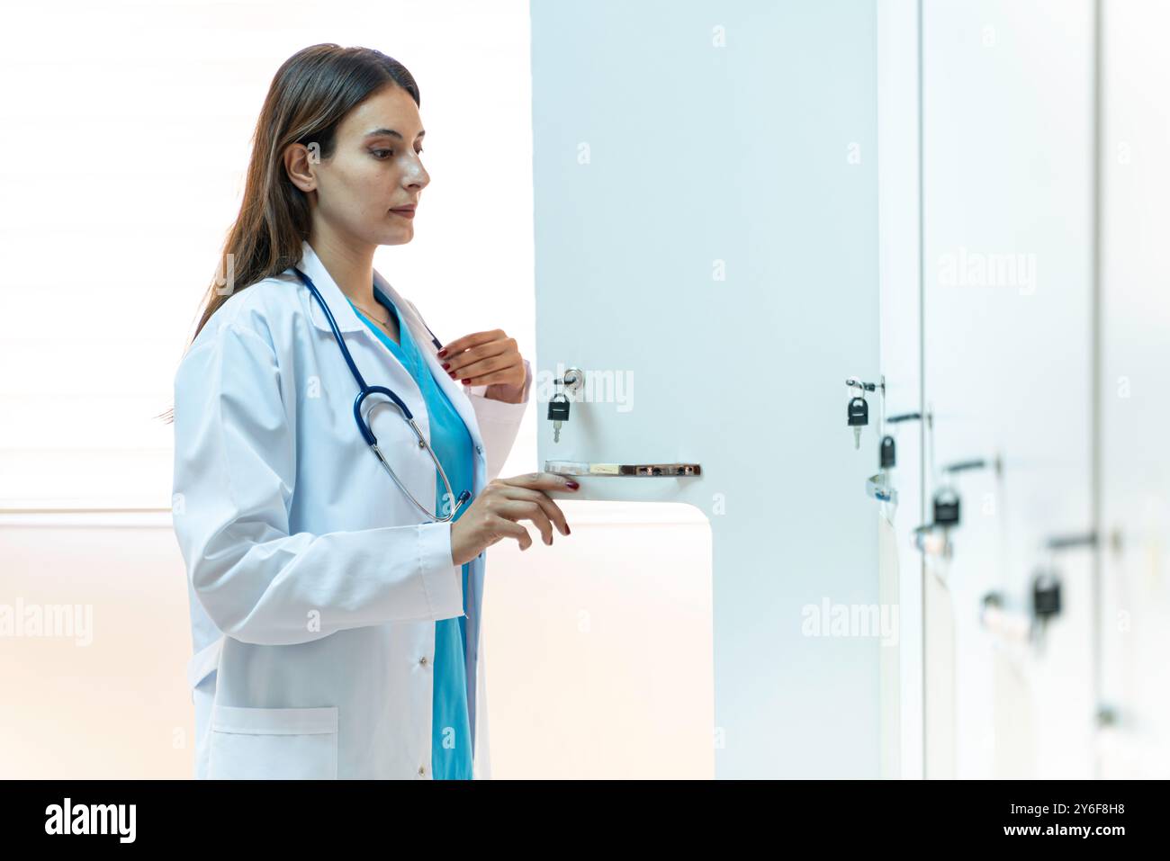 Young female doctor in a changing room putting his clothes to the ...