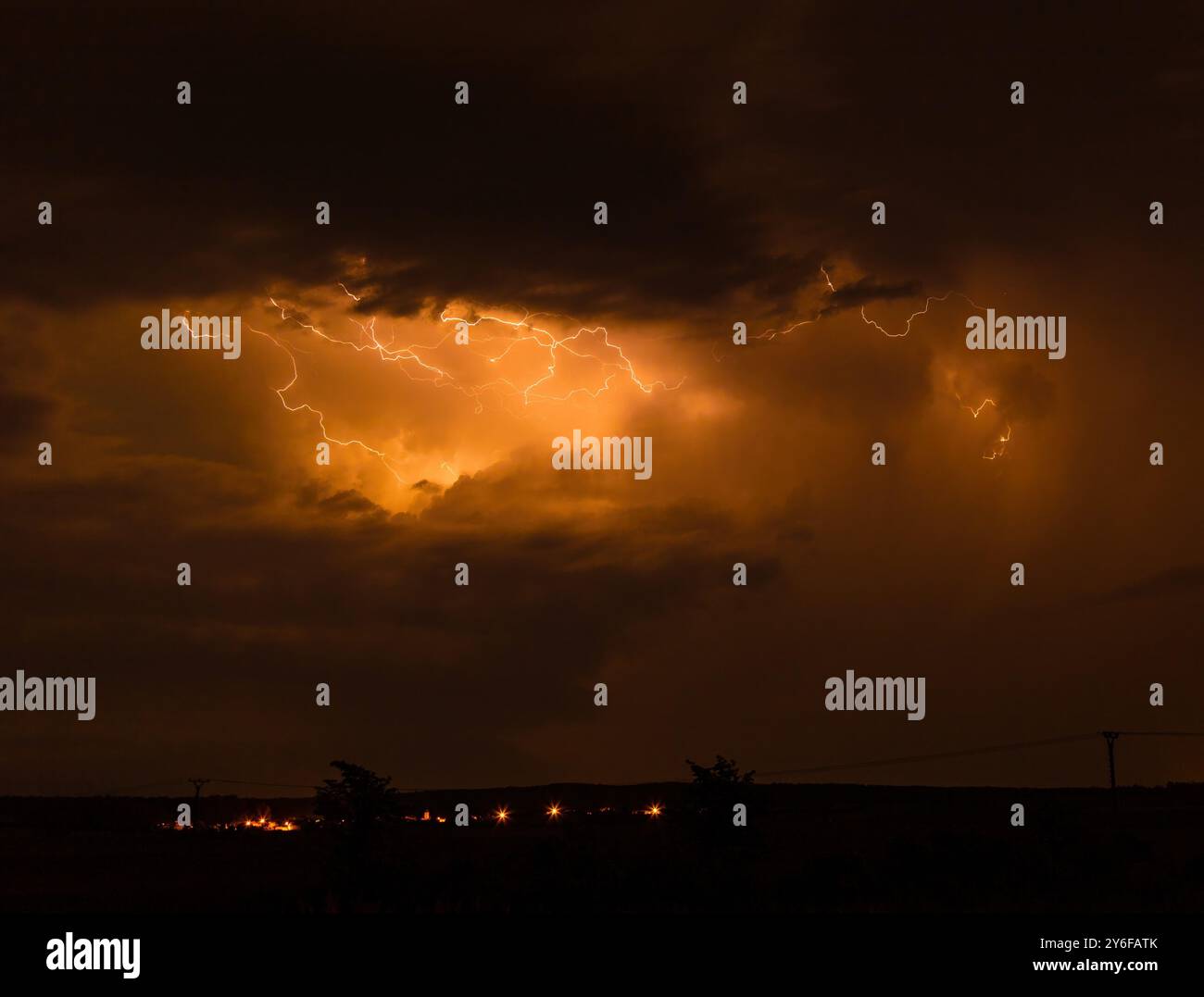 Dramatic lightning storm illuminating the night sky over a dark ...