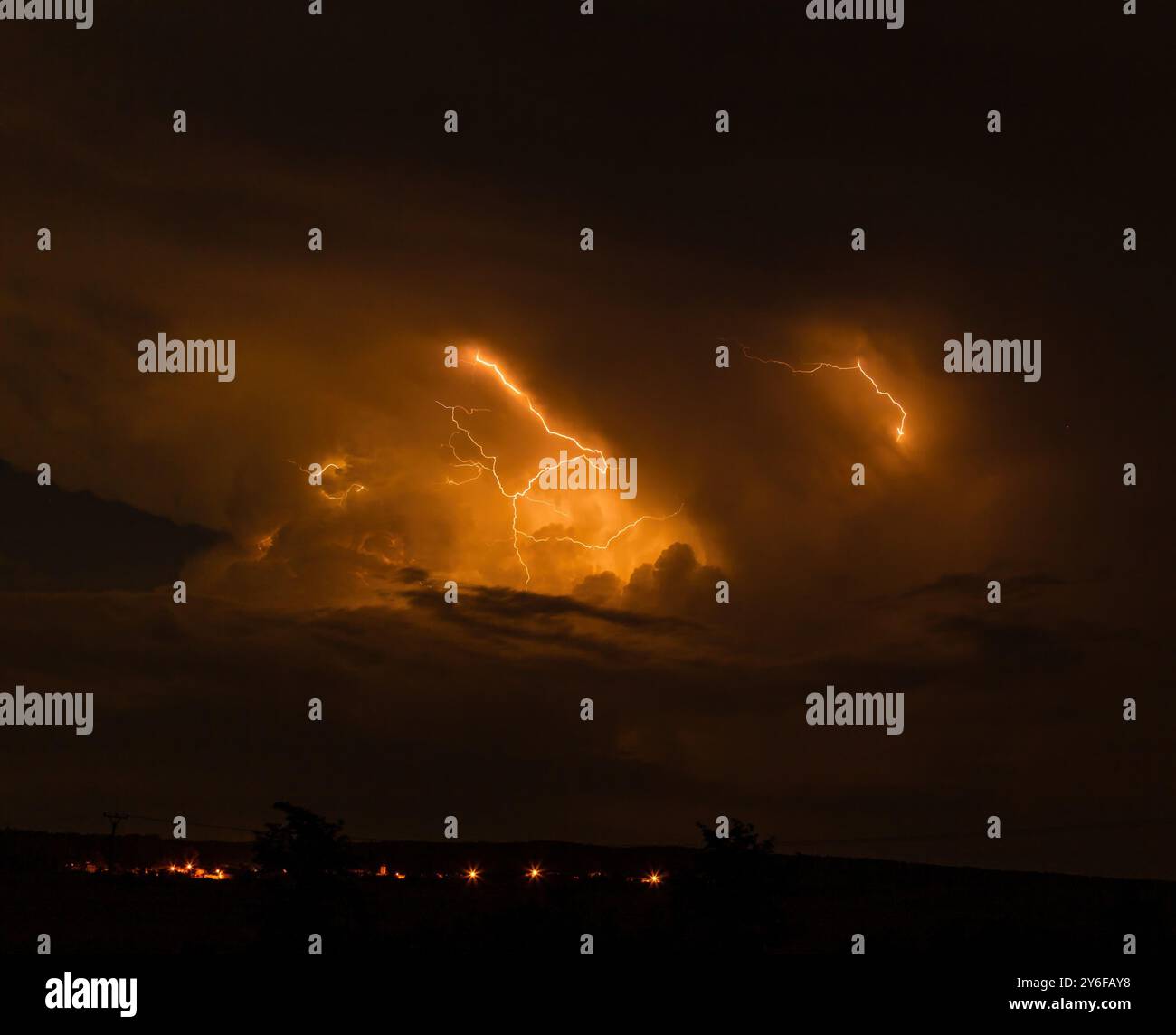 A dramatic night sky illuminated by lightning bolts during a ...