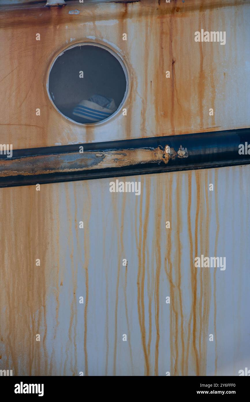 rusty old porthole staining the side of an abandoned or shipwrecked ...
