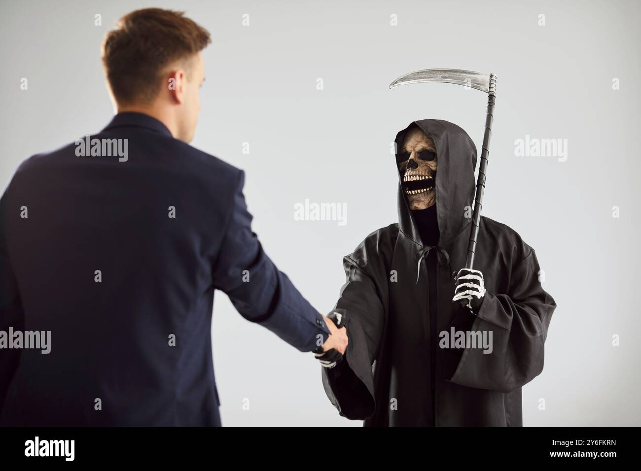 Grim Reaper of Death with scythe shoulder meeting new victim, young man ...