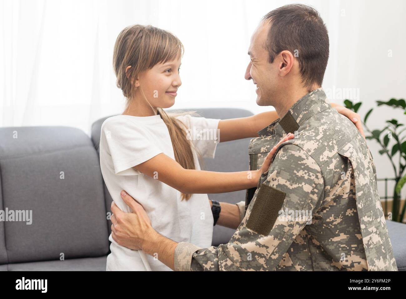 Little girl hugging her military father at home, closeup Stock Photo ...