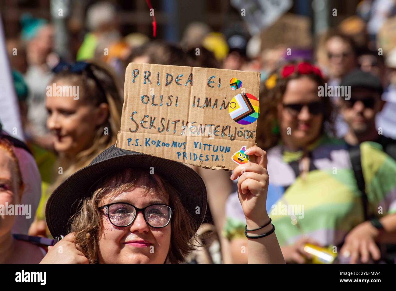 Woman with handwritten cardboard sign at Helsinki Pride 2024 parade on ...