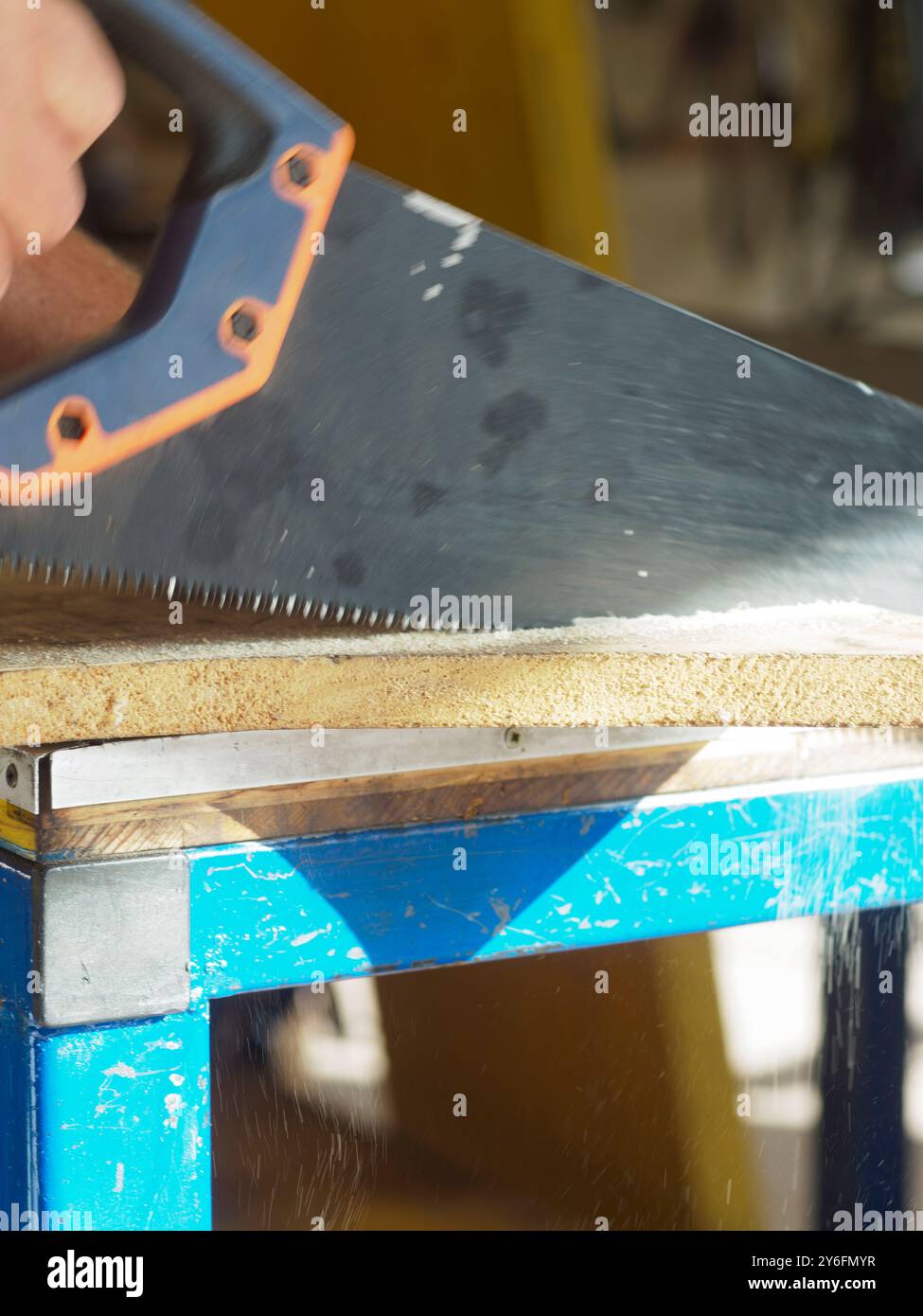 Construction worker skillfully saws a wood plank with a handsaw, wood ...