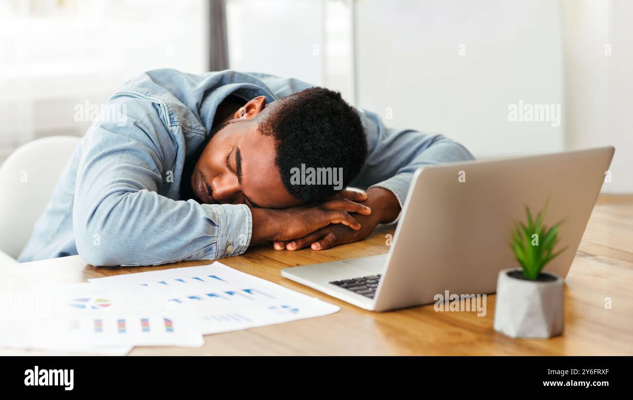 Overworked african american employee sleeping at workplace in office ...