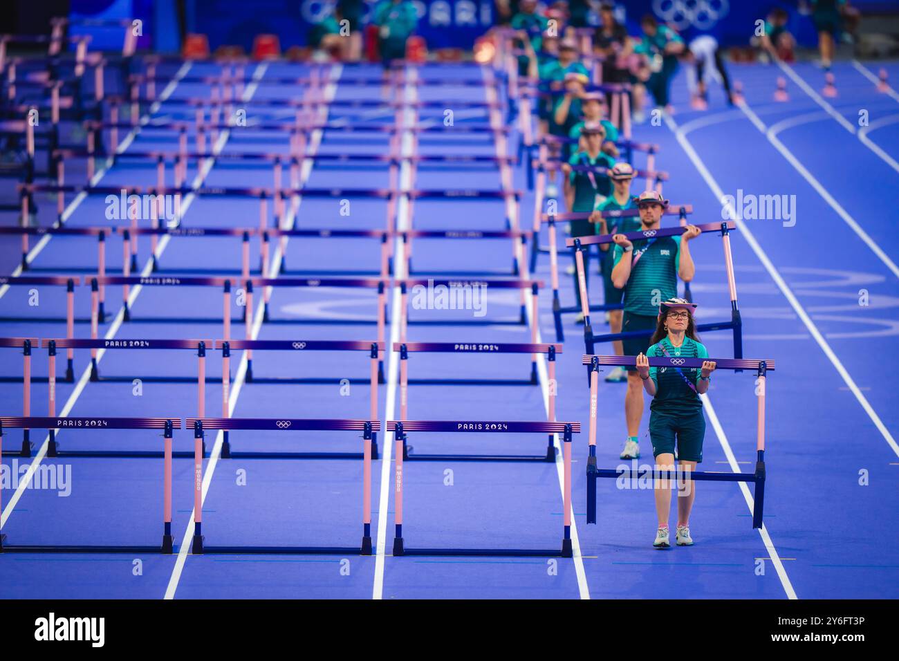 Athletics volunteer moving the hurdles in a synchronized manner at the ...