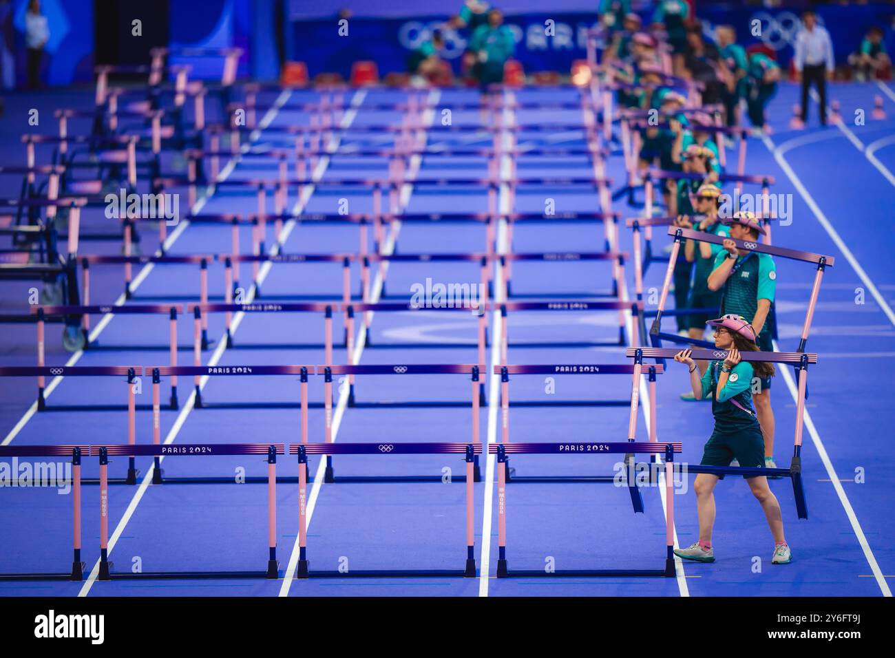 Athletics volunteer moving the hurdles in a synchronized manner at the ...