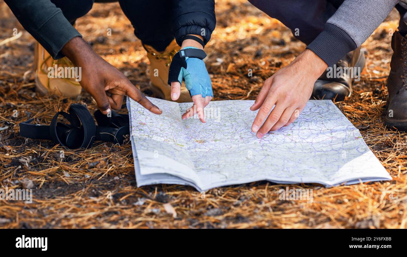 Backpackers pointing at map, looking for their location at forest Stock ...