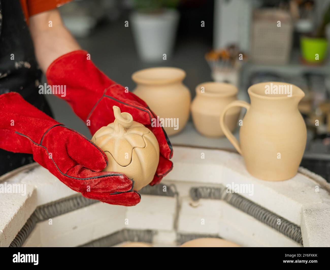 Close-up of a man's hands loading ceramics into a special kiln Stock ...