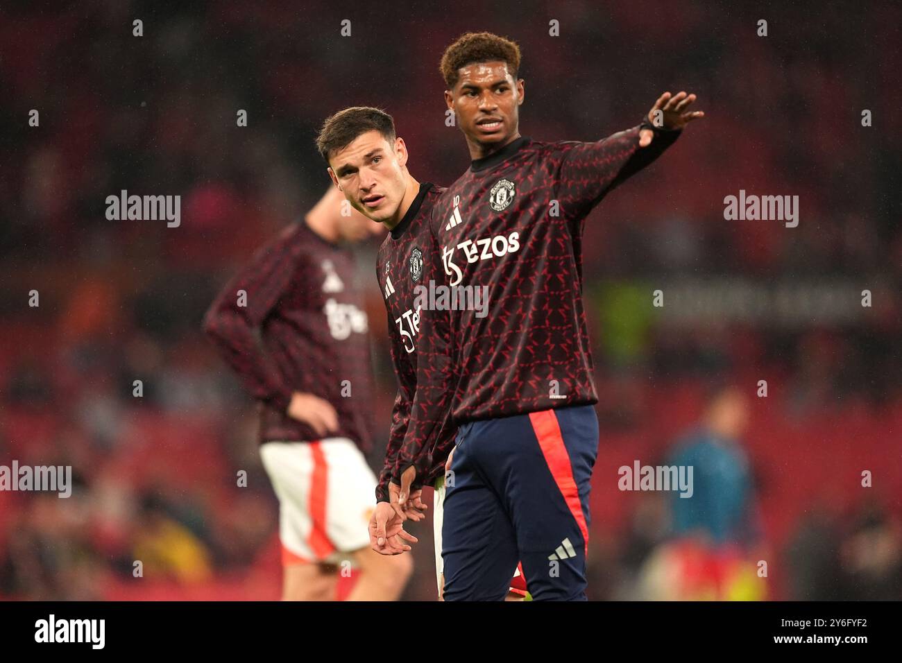 Manchester United's Manuel Ugarte (left) speaks with team-mate Marcus ...