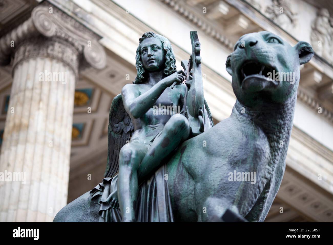 A detailed bronze statue featuring a winged figure riding a lion ...
