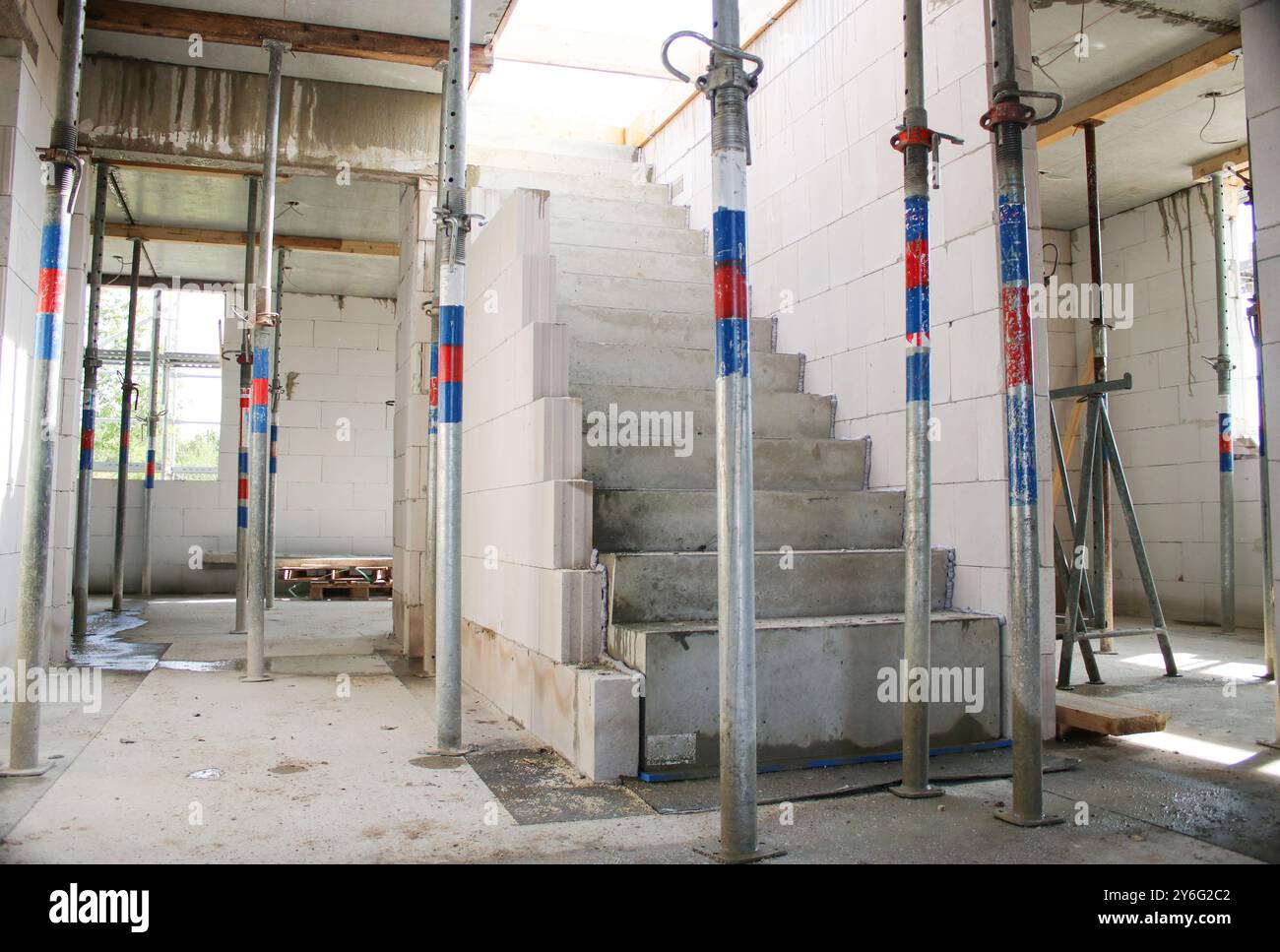 Inside view of a new building with concrete stairs and support beams ...