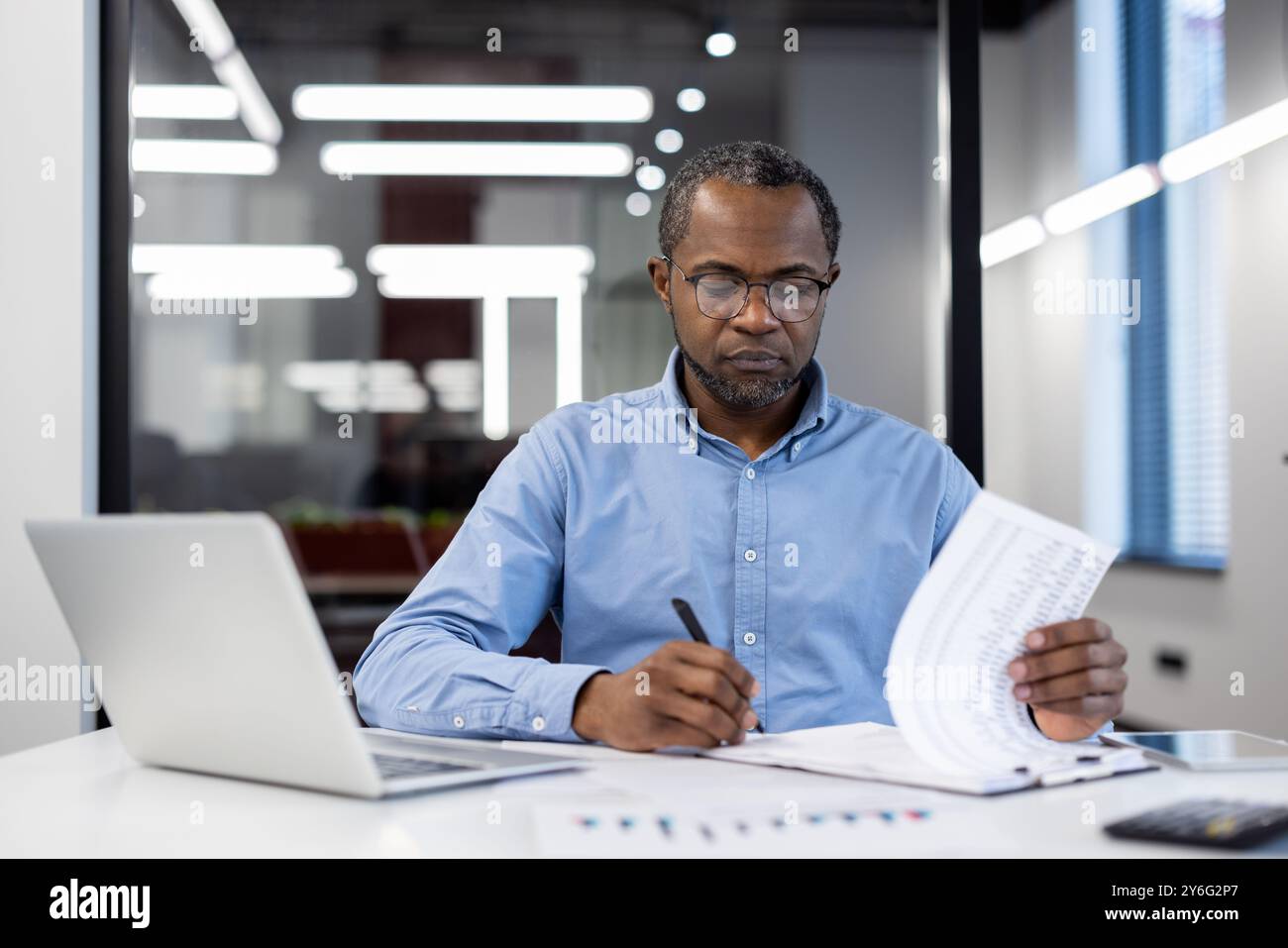 Focused professional in office setting reviewing financial paperwork ... Focused professional in office setting reviewing financial paperwork ...