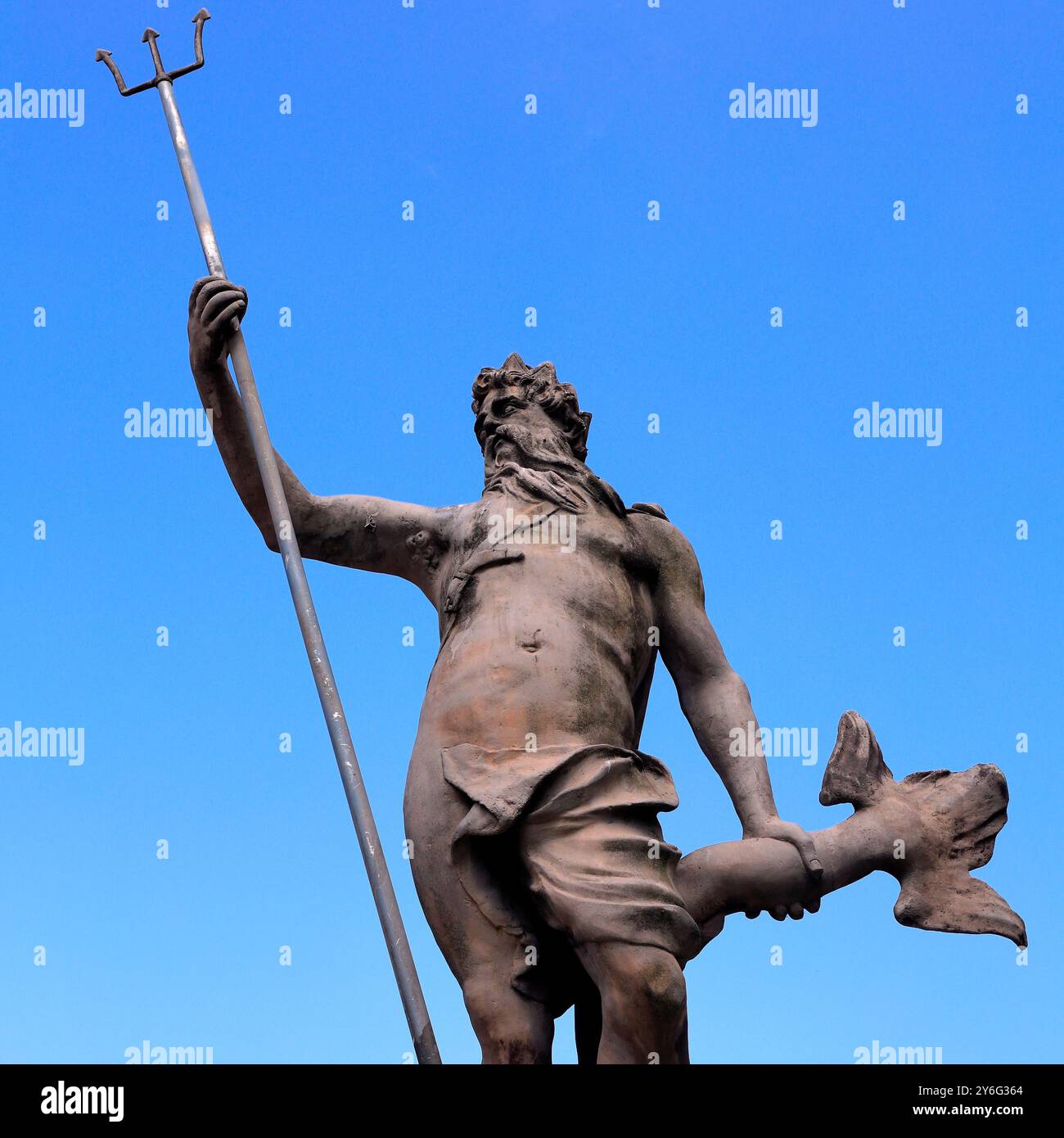 Large statue of Neptune / Poseidon and trident against blue sky ...