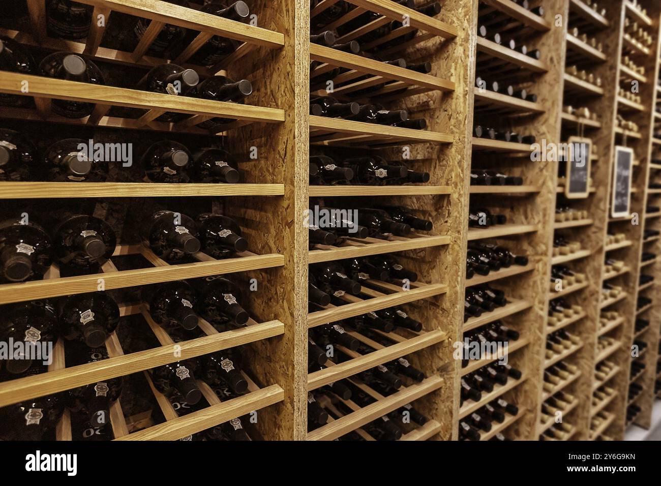 Bottles with wine stacked on wooden racks Stock Photo - Alamy