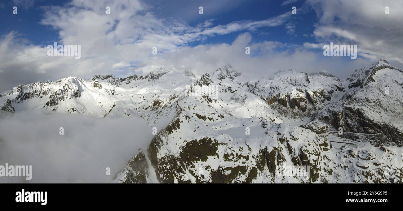 Aerial panorama landscape with clouds between snow-capped mountains Stock Photo - Alamy