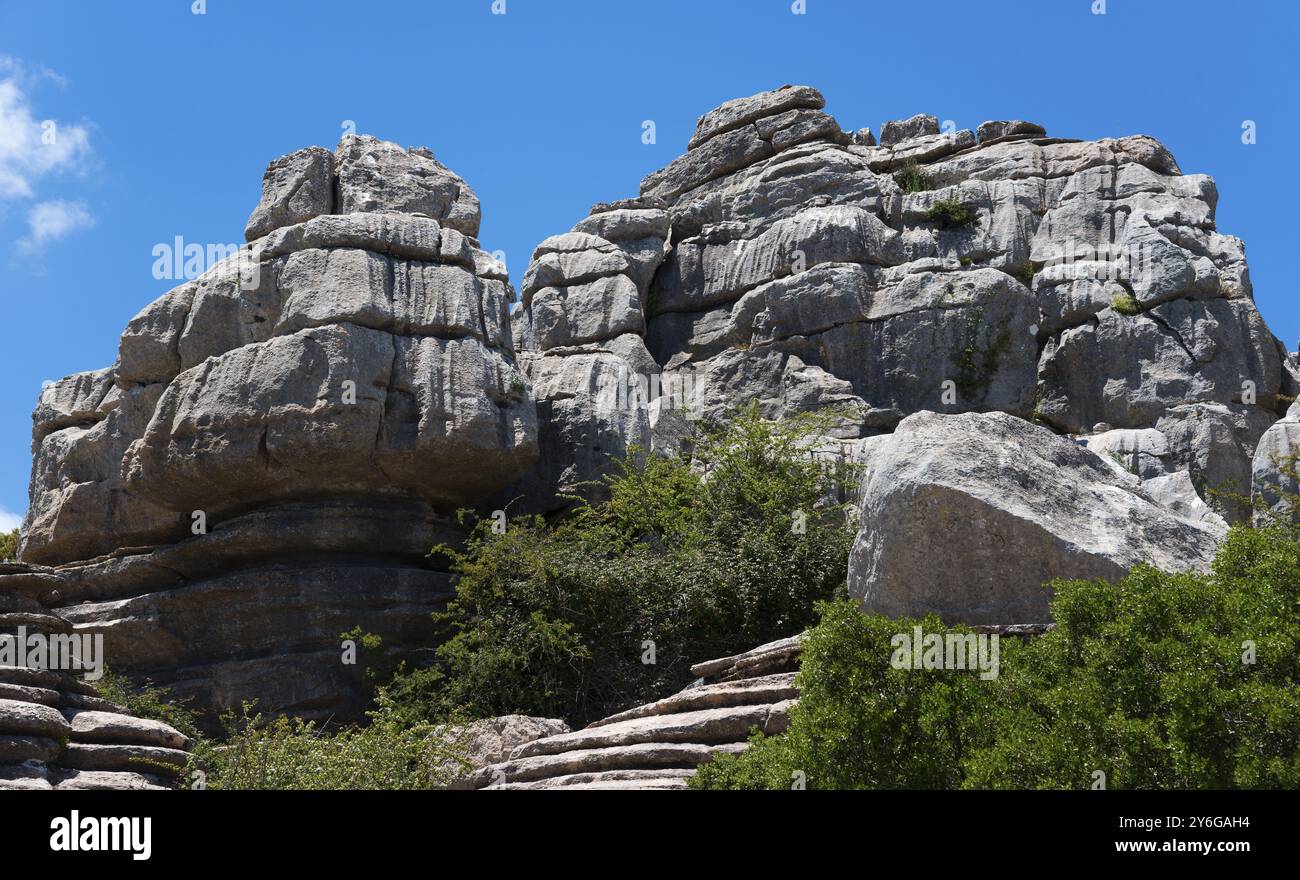Massive rock face with green vegetation under a clear blue sky, karst ...