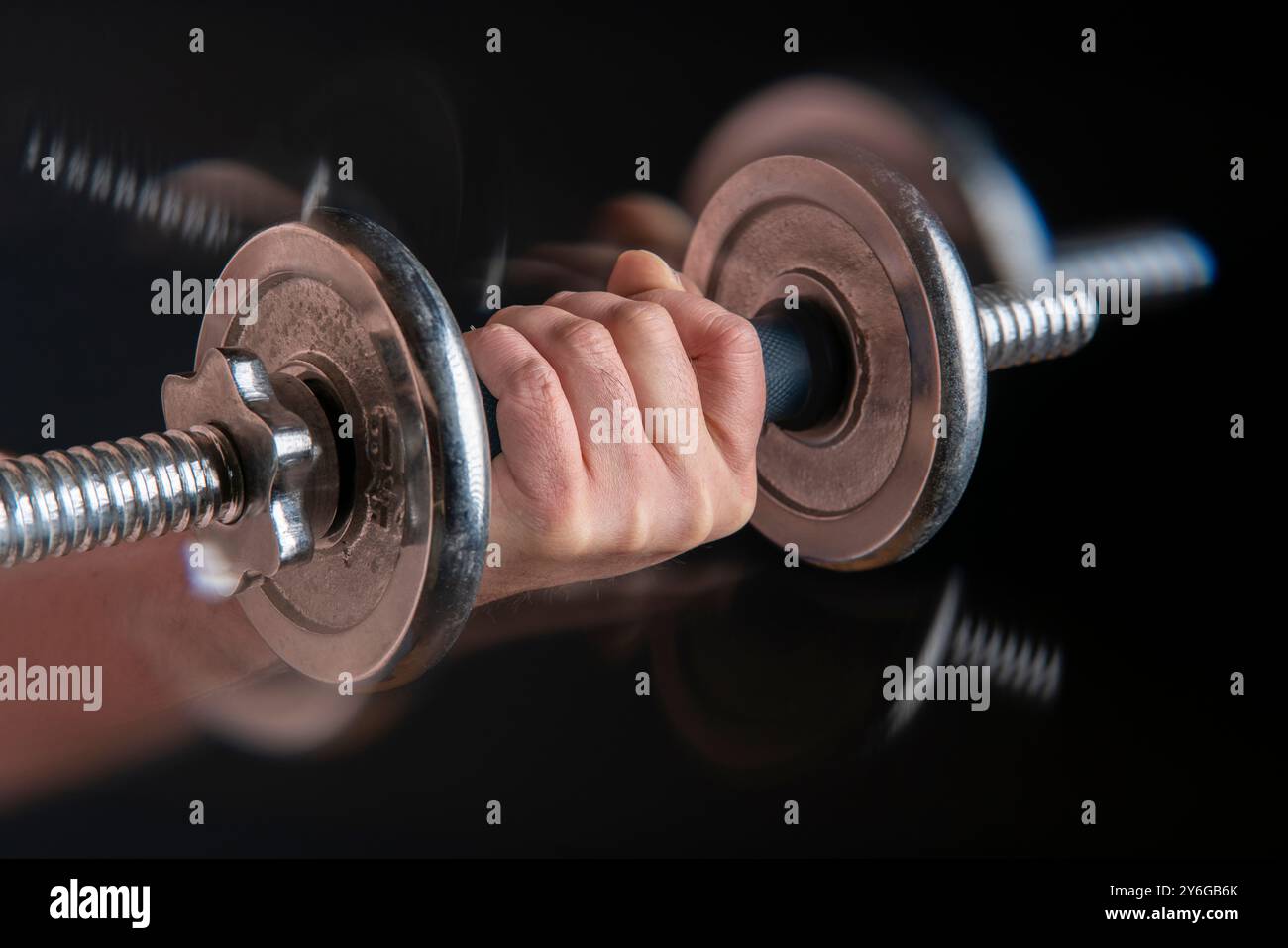 Close up of man's hand exercising with heavy dumbbell with motion ...