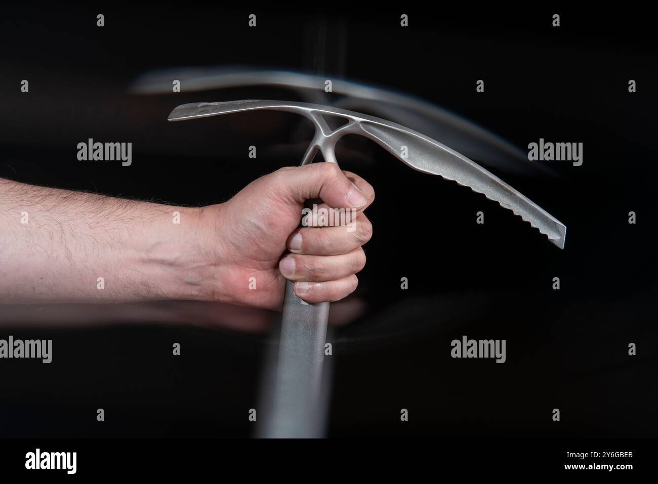 Close up of man's hand holding a climbing ice axe with motion effect ...