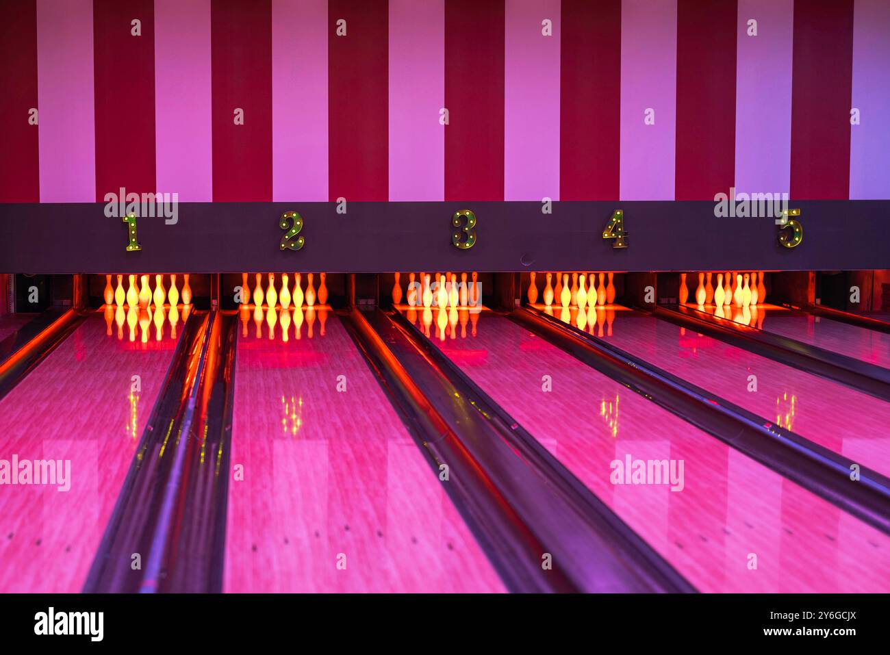 Bowling alley with five lanes and brightly lit pins ready for game ...