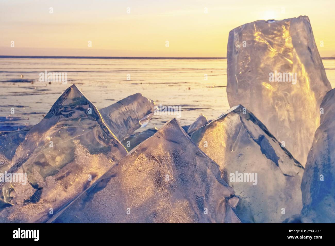 Sunset on frozen Lake Baikal landscape, sunlight is refracted in ice ...
