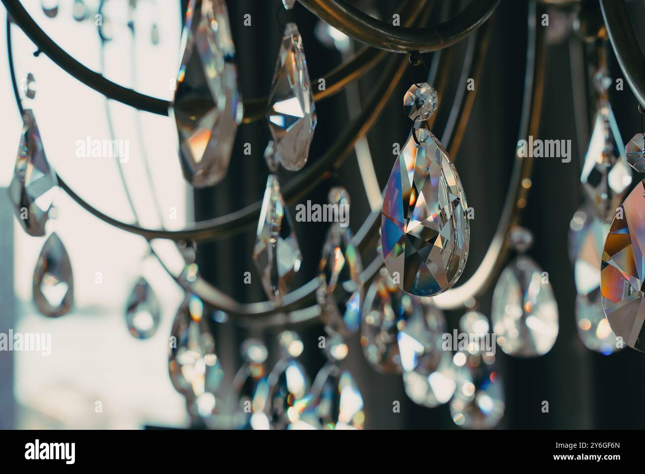 Close-up of sparkling crystal drops hanging from a golden chandelier ...