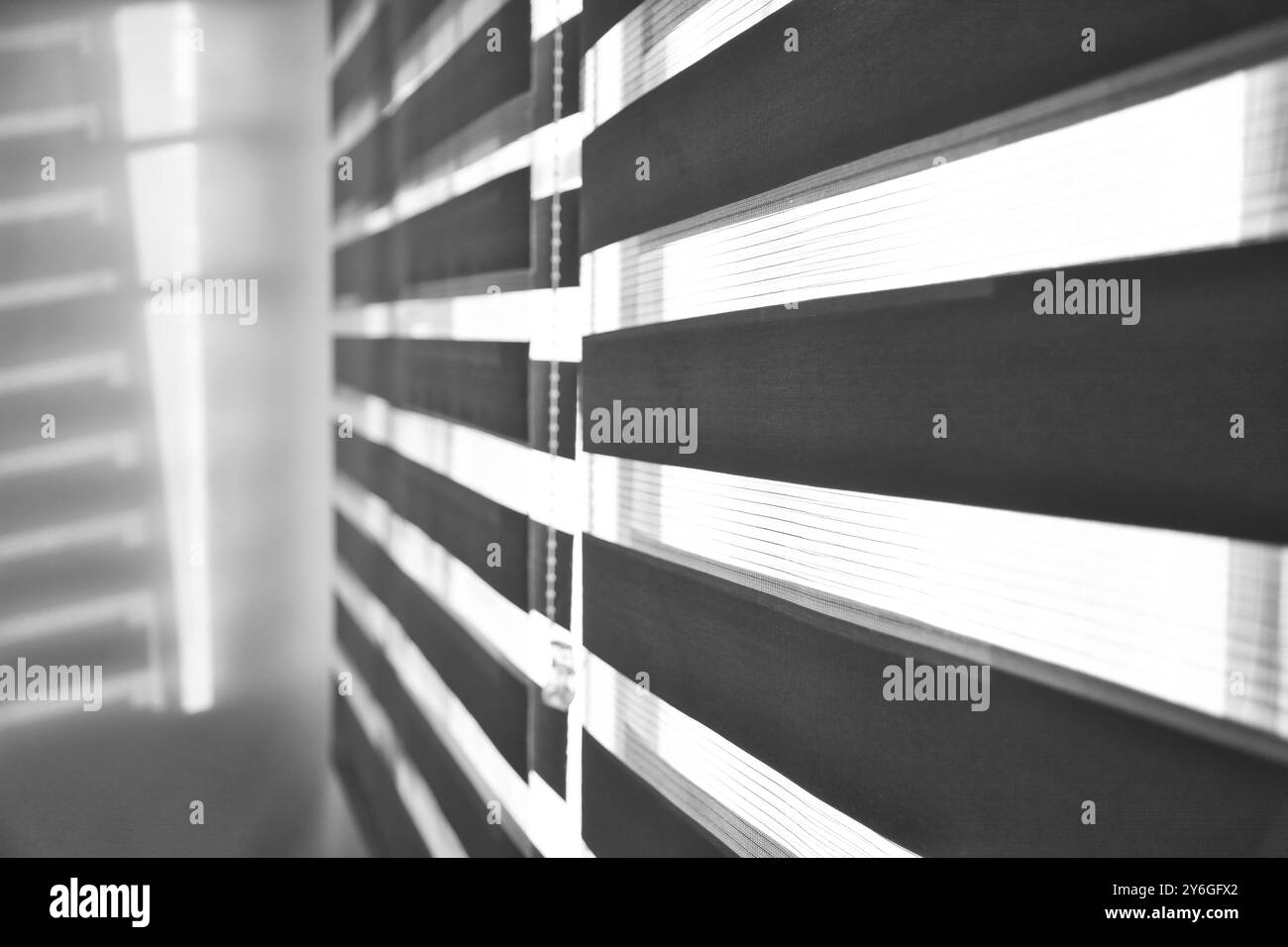 Sun shining through window roller blinds throwing shadows on the wall ...