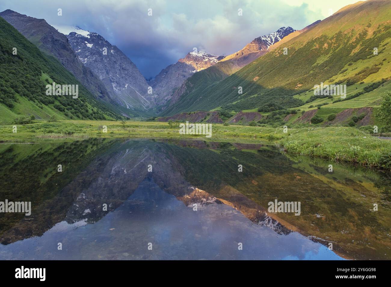 Beautiful landscape with high mountains with illuminated peaks ...