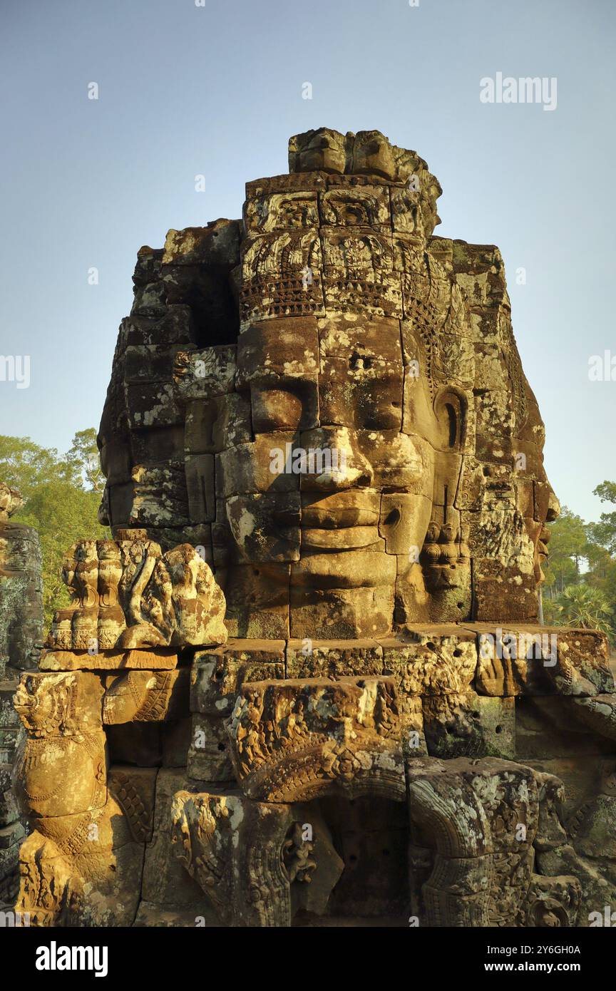 Giant stone faces at Bayon Temple at sunset, Angkor Wat, Cambodia, Asia ...