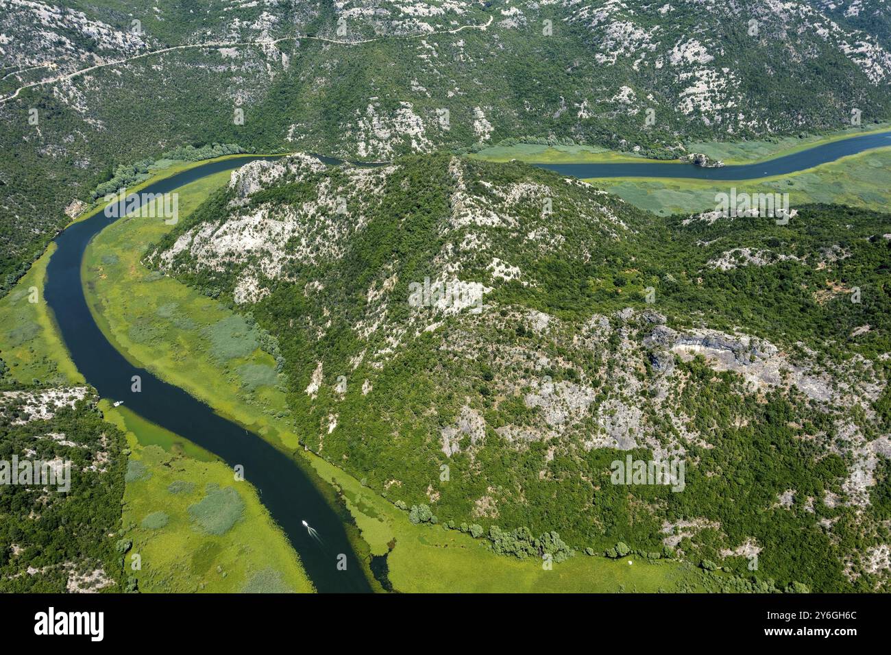 Aerial view of Rijeka Crnojevica, boats on beautiful river between mountains flowing into Skadar ...