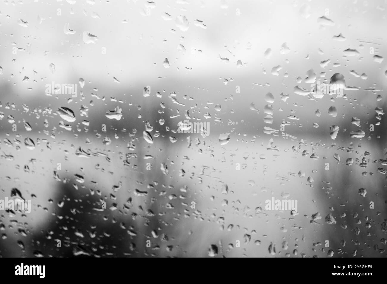Raindrops on a window, illustrating gray and rainy weather during the ...