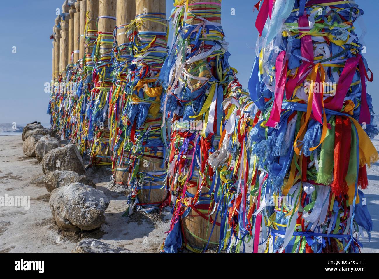 Wooden ritual pillars with colorful ribbons and Shaman rock, one of ...