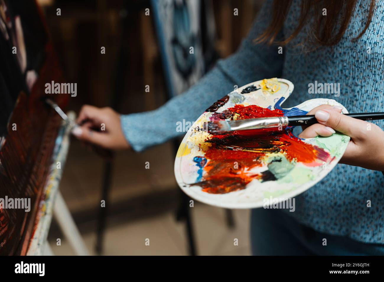 Artist mixing vibrant paint colors on a palette during creative session ...
