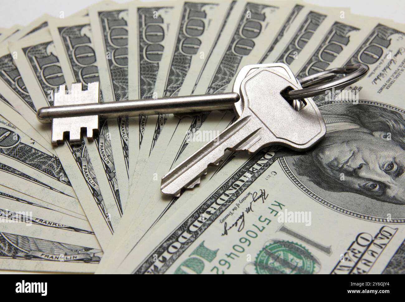 Buying house, keys on stack of hundred-dollar bills Stock Photo - Alamy