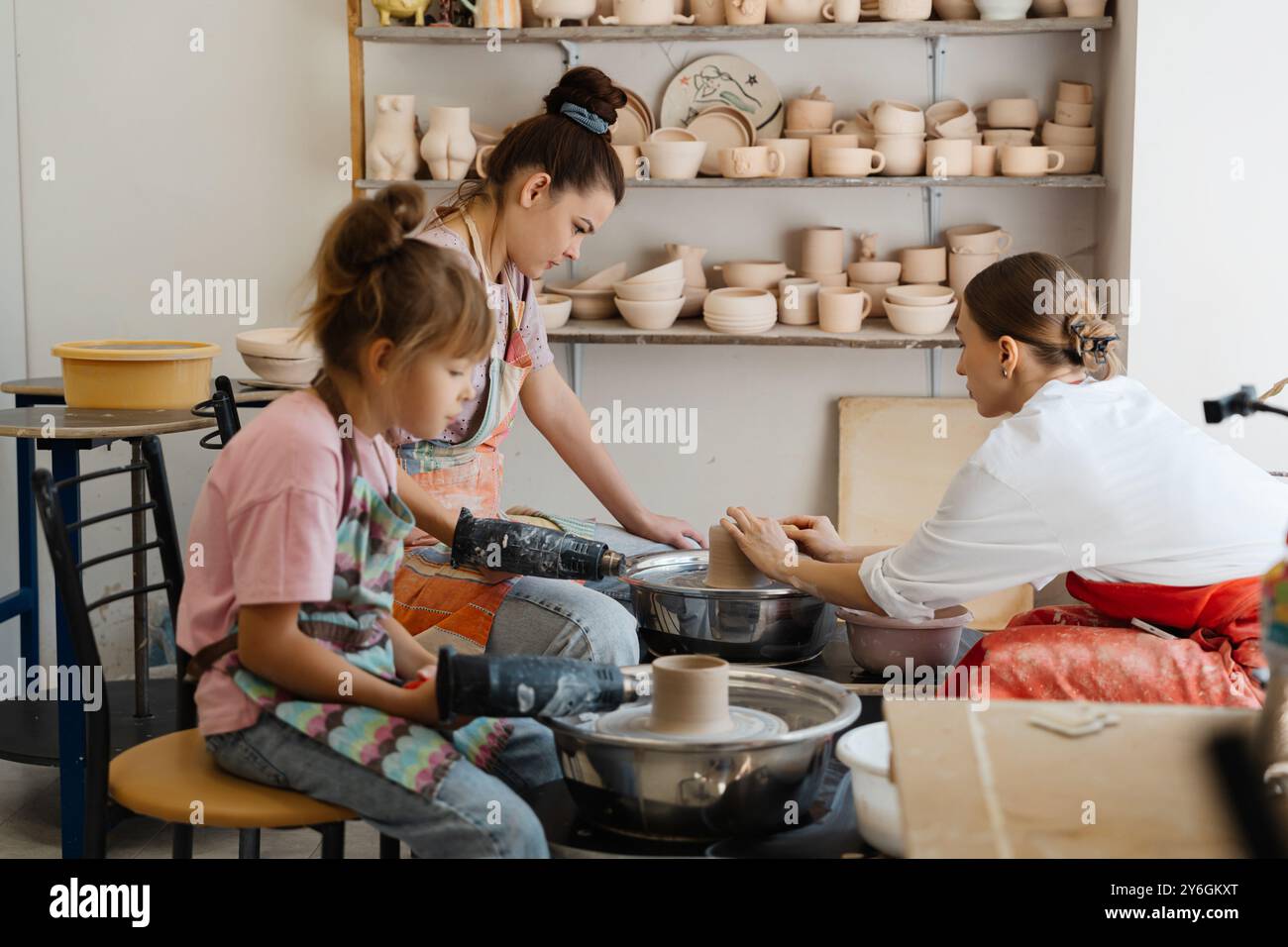 Children and adults creating pottery together in a bright studio Stock ...