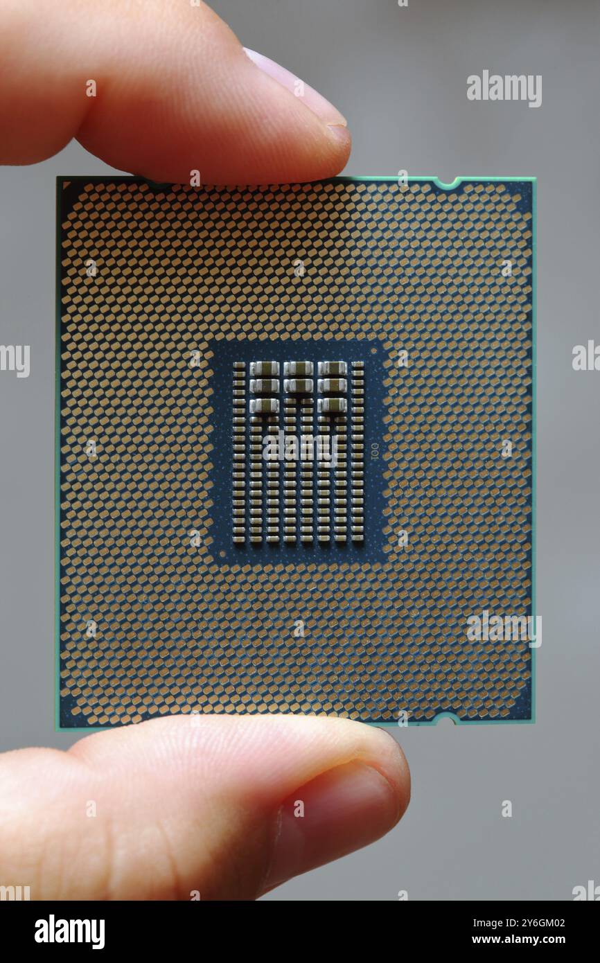 The fingers of man hold a modern central processor unit CPU macro Stock ...