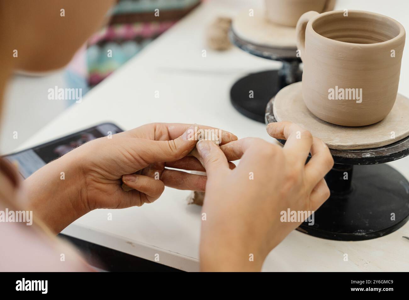 Creating pottery by hand during a pottery class in a studio setting ...