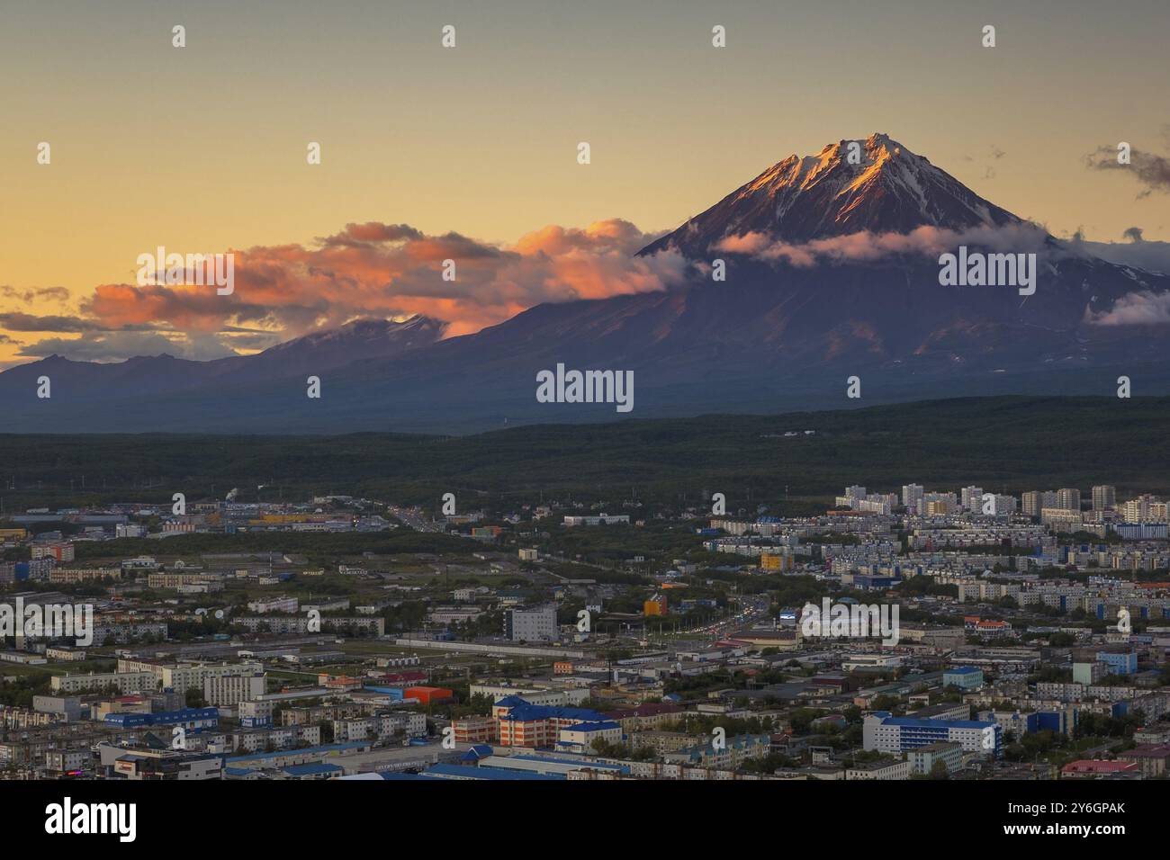 Petropavlovsk-Kamchatsky city at sunset and cone of Koryak volcano ...