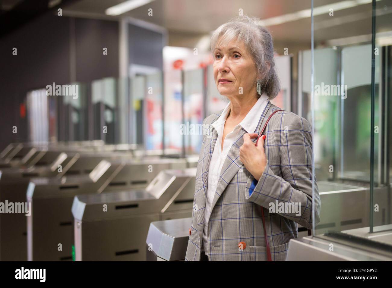 Mature lady going through ticket barriers in metro station Stock Photo ...