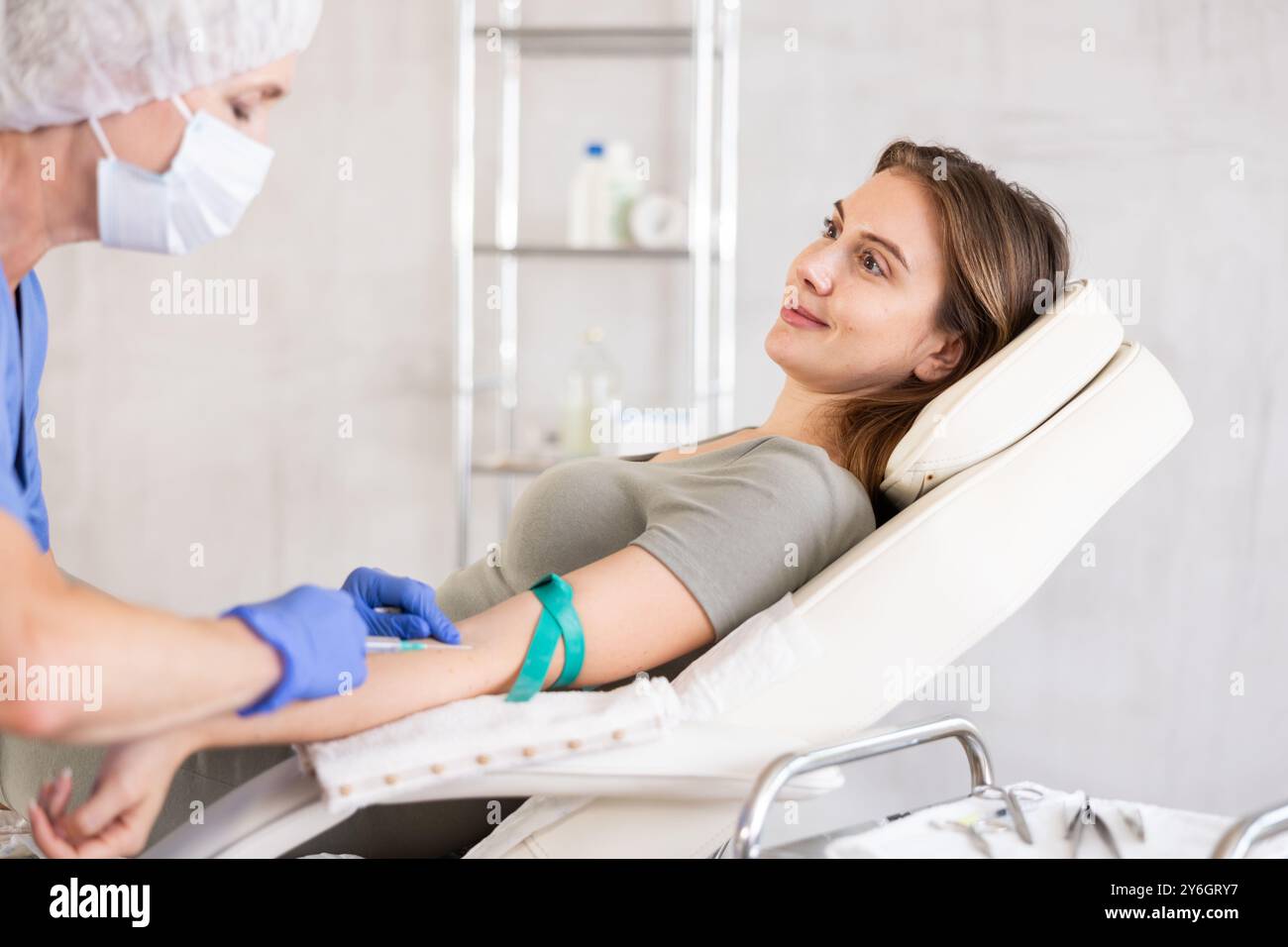 Elderly doctor drawing blood from young patient Stock Photo - Alamy