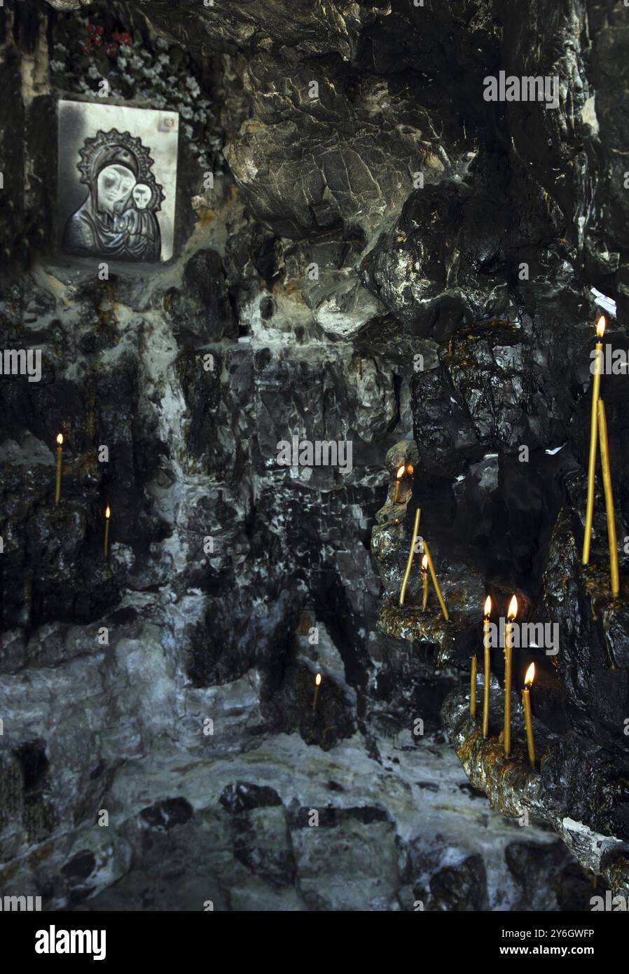 Christian holy place, icon and candles in grotto Stock Photo - Alamy