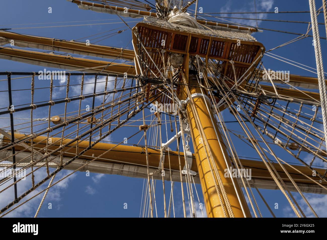 Low angle view of sailboat wooden ship masts and rigging under blue sky ...
