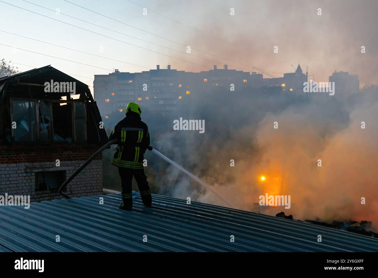 Firefighter extinguish fire in house using spraying hose Stock Photo ...