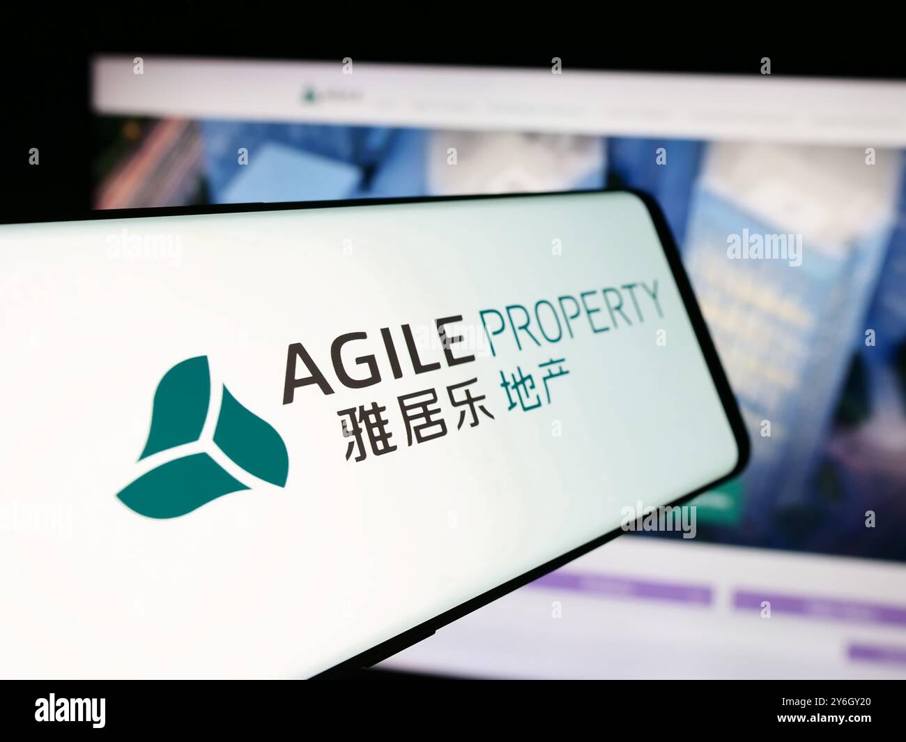 In this photo illustration, a mobile phone with the logo of Chinese company Agile Property ...