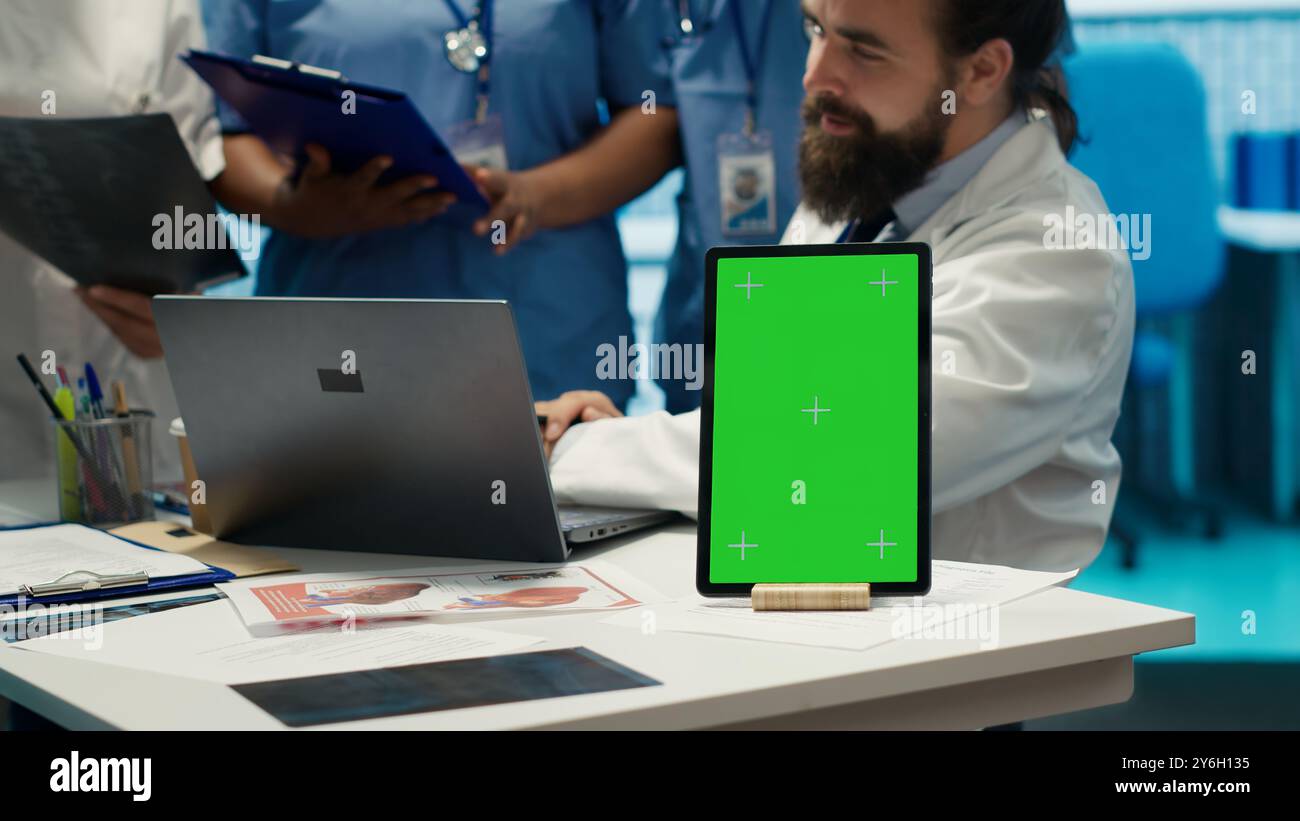 Doctors and nurses review radiography scans with green screen on desk ...